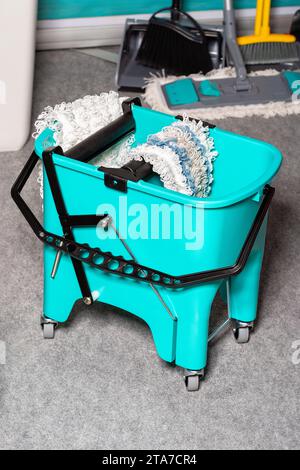 A turquoise cleaning trolley for cleaning tools and a removable gray ...