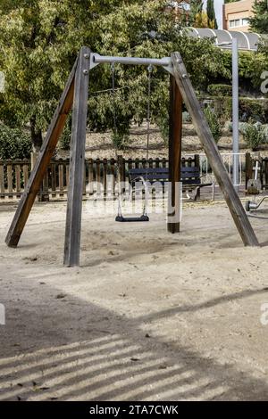 An urban playground with swings and slides and other games on a sandy ...
