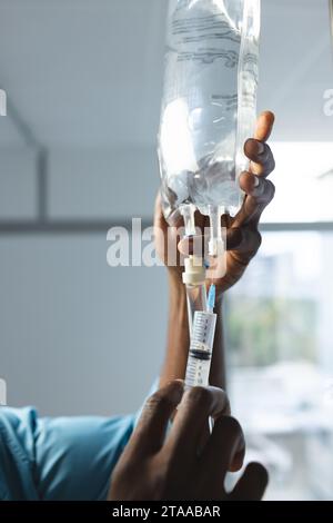Hands of african american male doctor applying drip in hospital room ...