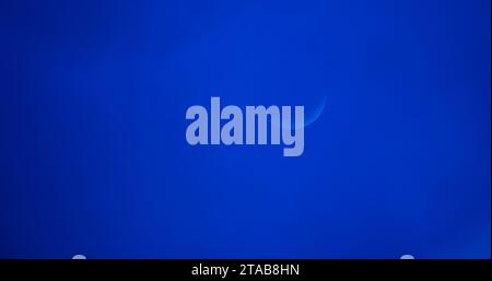 Crescent moon cloaked in a sky of deepest blue Stock Photo - Alamy