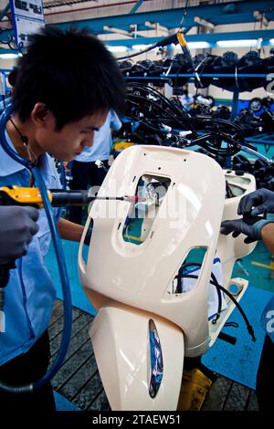 Workers assemble Vespas on the assembly line at the Piaggio Factory ...
