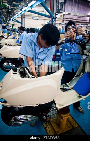 Workers assemble Vespas on the assembly line at the Piaggio Factory ...