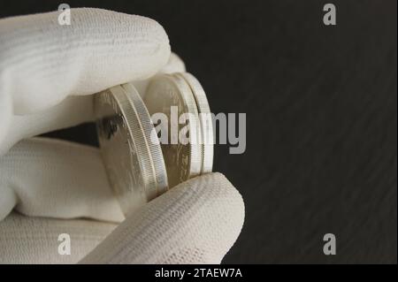 Grooved coin edges. Silver coins in the hand of a numismatist Stock ...