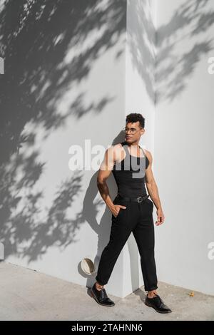 Cuban man in a black tank top works out at an outdoor fitness park ...