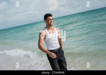 Carefree and muscular young cuban man standing in Miami South Beach ...
