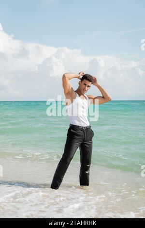 handsome and muscular Cuban man standing in ocean water in Miami South ...