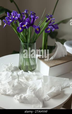 Seasonal allergy rhinitis to flowers. Bouquet of purple iris flowers in ...