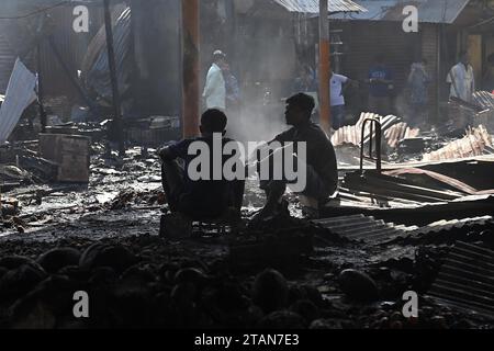 Shop owners and vendors are seen in front of their burnt shops and ...