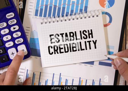 ESTABLISH CREDIBILITY text on paper clipboard with chart and notebook ...