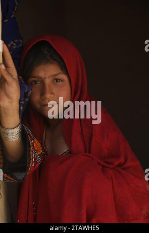 Happy Afghan young girl with a traditional outfit, smiling, looking at ...