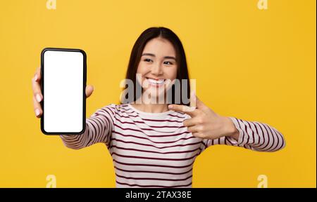 Pretty young Asian woman showing heart gesture on blue background ...