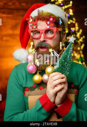 Bearded guy in sweater and hat near fir trees Stock Photo - Alamy