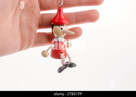 Pinocchio puppet in hand on a white background Stock Photo - Alamy