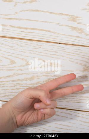 Hands making rock, paper, scissors gesture on a wooden background Stock ...