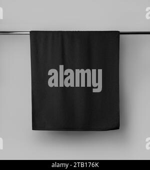 Mockup of a black terry towel with a label, folded in half, for design ...