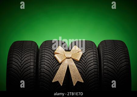 Car tires, new tyres, winter wheels gold bow ribbon present, text 2024 ...