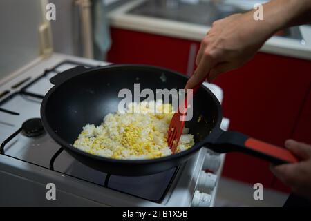 Hands of a young man making fried rice with eggs in a work, asian ...
