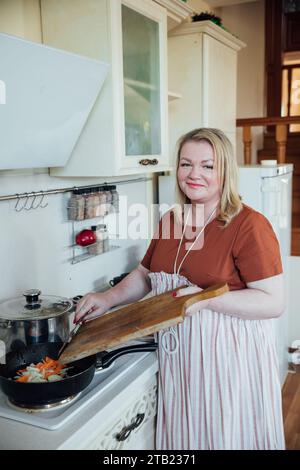 Beautiful woman frying rice with vegetables in kitchen Stock Photo - Alamy