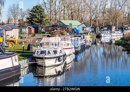 Boats moored at Lakeside Lodge, with reflections in the still water ...