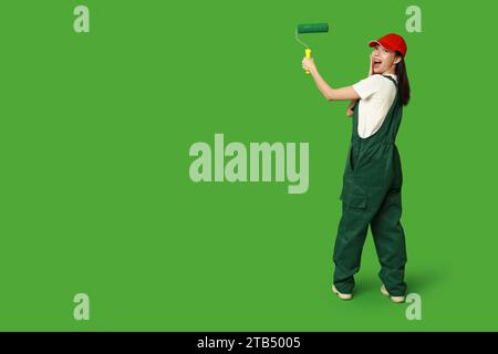 Female Asian shocked painter with roller on green background Stock ...