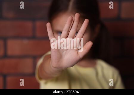 Child abuse. Little girl doing stop gesture on dark background ...