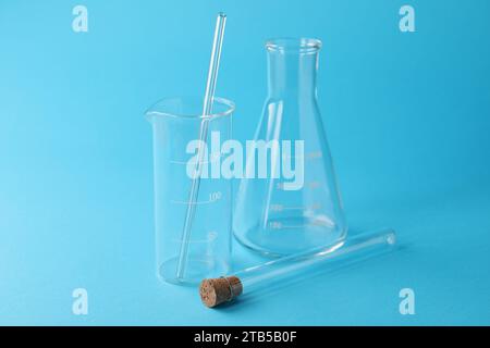 Different laboratory glassware on light blue background Stock Photo - Alamy