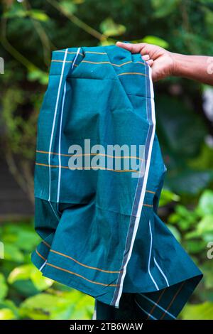 Folded Cotton Fabric Lungi hand holding with gray Background ...