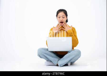 Shocked woman looking at laptop screen confused, stunned about smth on ...