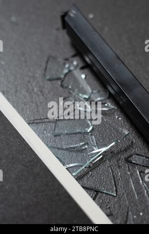 A broken picture frame on a tiled floor, with the frame itself broken ...