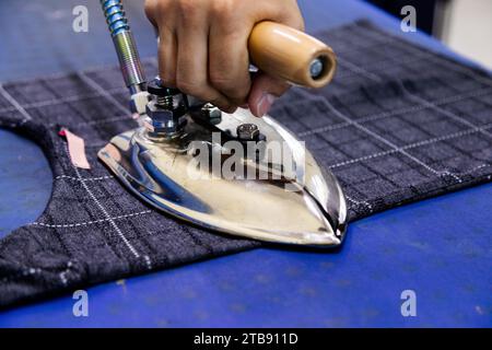 Tailor ironing clothes in tailoring shop with steam Iron Stock Photo ...