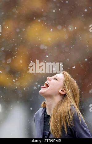 Young woman spends time outside during the first snow of winter ...