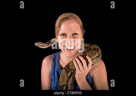 Young woman holds a Red-tailed boa constrictor (Boa constrictor ...