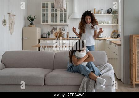 Angry woman mother blaming scolding sad girl daughter at home, dealing with child behavior ...