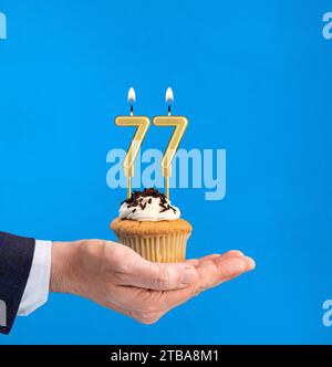 Birthday cupcake with candle number 77 - Birthday card on pink ...