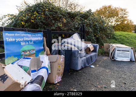 A fly tipping site including cardboard boxes, a couch, suitcase and ...