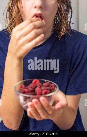 teenage girl eats red raspberries with her mouth wide open Stock Photo ...