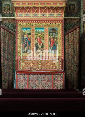 Reredos with tryptich paintings of Jesus Christ behind the altar in the ...