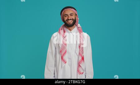 Young muslim man saying yes nodding on camera, presenting agreement ...