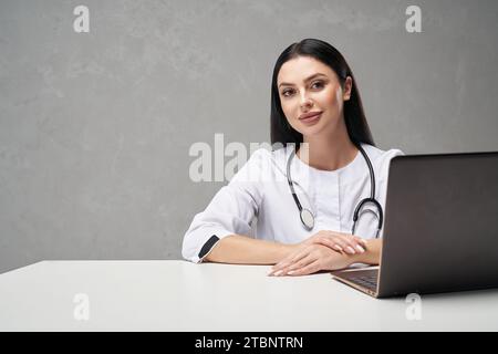 Brunette female doctor using laptop computer in hospital. Healthcare ...