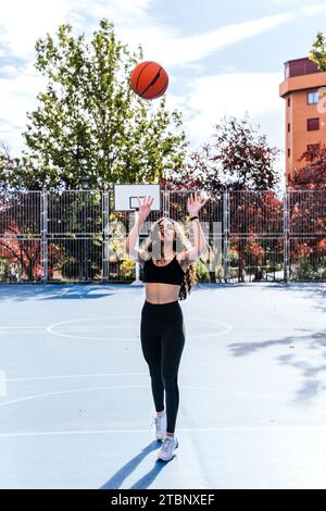 Girl playing basketball. Player throwing ball. Outdoor sports field in ...