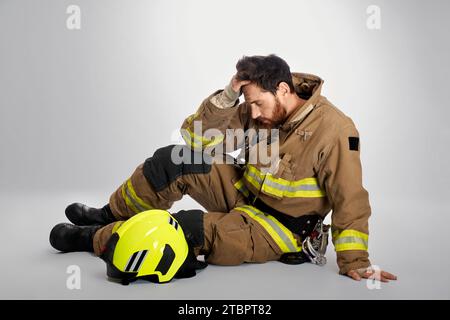 Sad, despaired firefighter crying, rubbing forehead, while sitting on ...