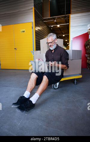 Cheerful bearded long-haired middle-eastern guy with glasses enjoying ...