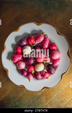 trimmed pink, red, purple, white radishes on white plate with gold ...