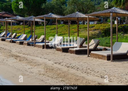 Clean beach with beds under straw umbrellas Stock Photo - Alamy
