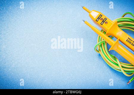 Yellow electrical tester cable on blue background electricity concept ...