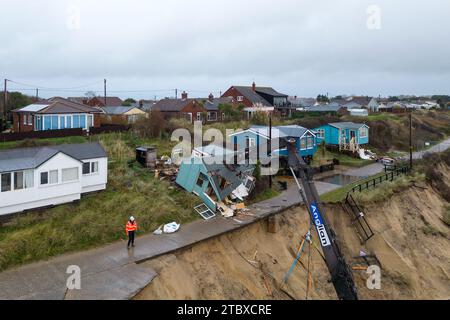 Demolition workers tear down the first of five clifftop homes in the ...