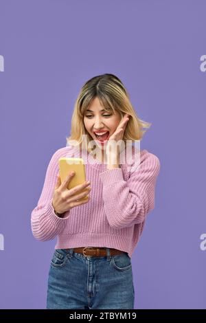 Excited gen z blonde young woman pointing up isolated on beige ...