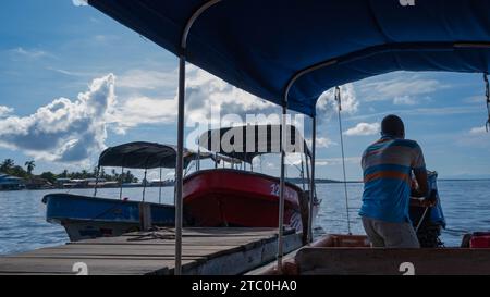 Boat driver starting engine of his water taxi, water taxi with canopy ...
