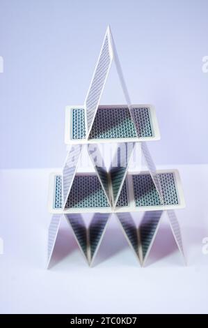 Playing card pyramid in balance made with poker cards on a blue ...