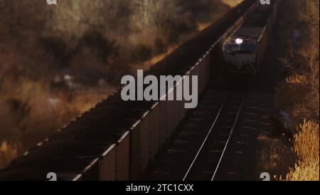 Freight train transporting coal, blasts the pastoral countryside and ...
